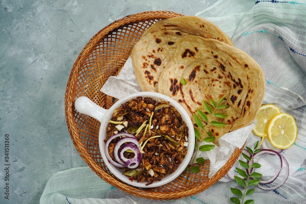 Lachha Paratha or Indian layered Roti with Pork Fry, selective focus ...