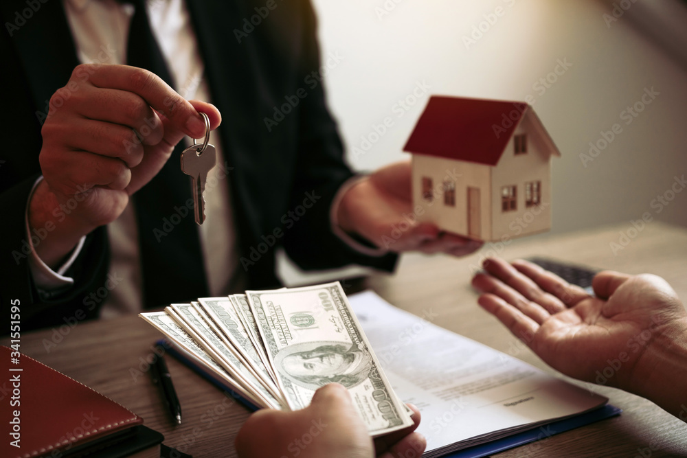 Businessman handed the house model and new homeowner giving money to ...