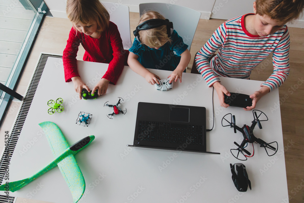 kids programming planes and drones, boy and girls with remote controls ...