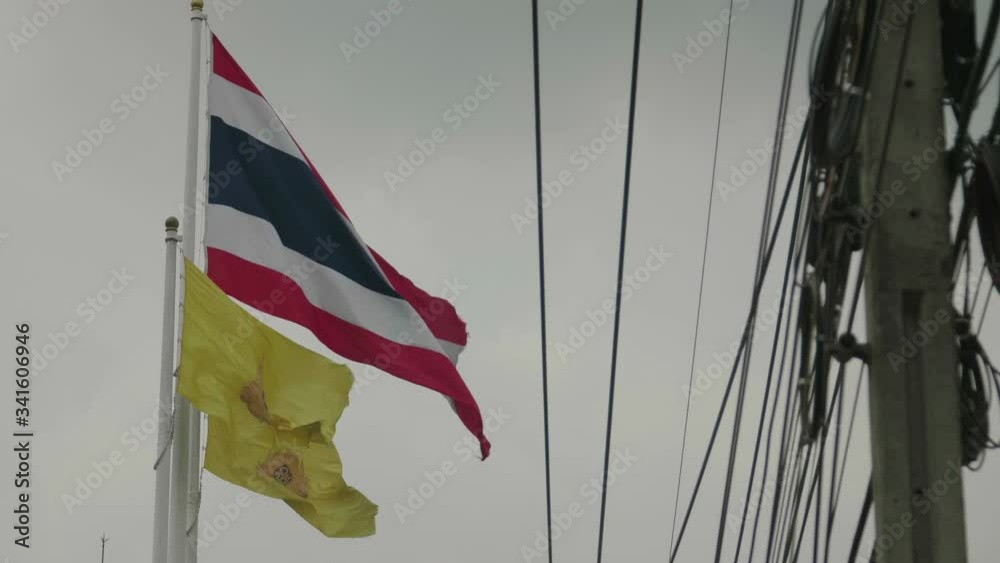 Thai national flag in half time slow motion with a couple of royal ...