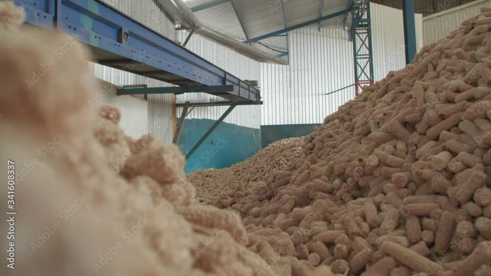 Empty corn cobs are being dumped by a conveying system to form mountain ...