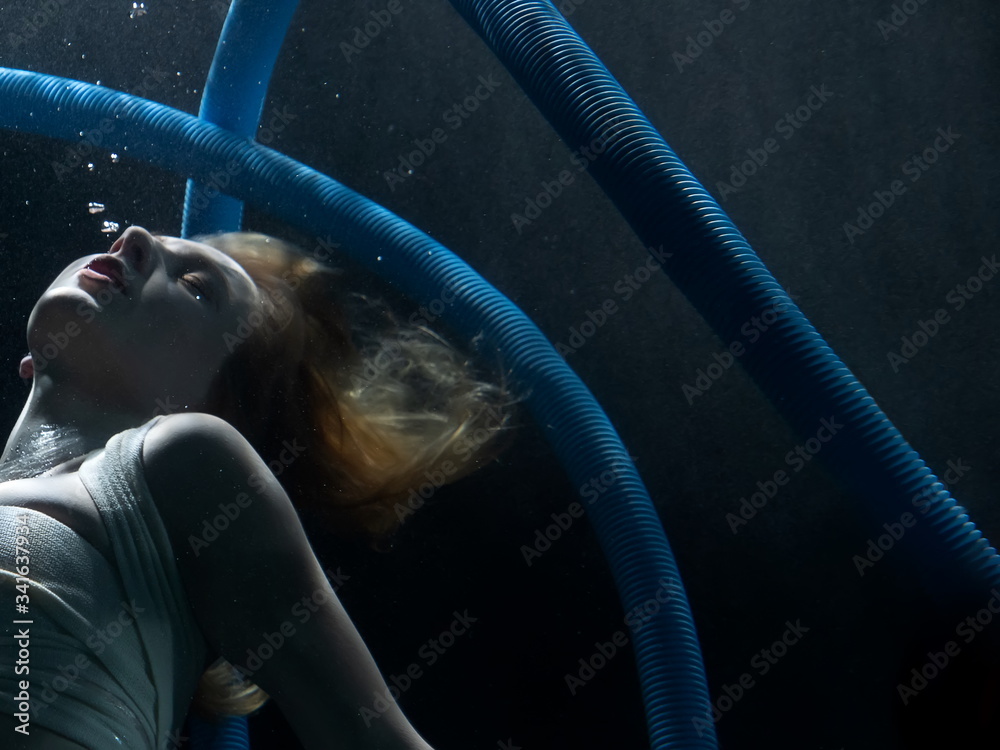 Woman swimming underwater among plastic trash. Girl drowning in sea ...