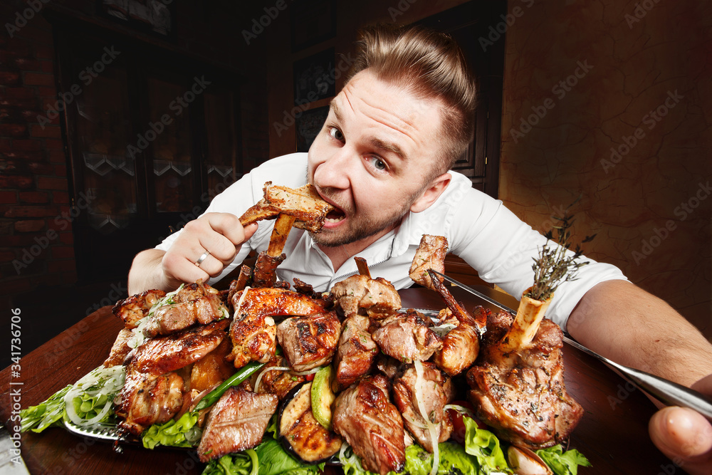 Crazy hungry man eating mix grill meat. Emotional content for ...
