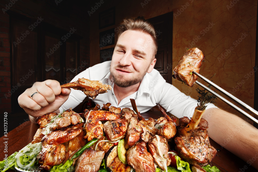 Crazy hungry man eating mix grill meat. Emotional content for ...