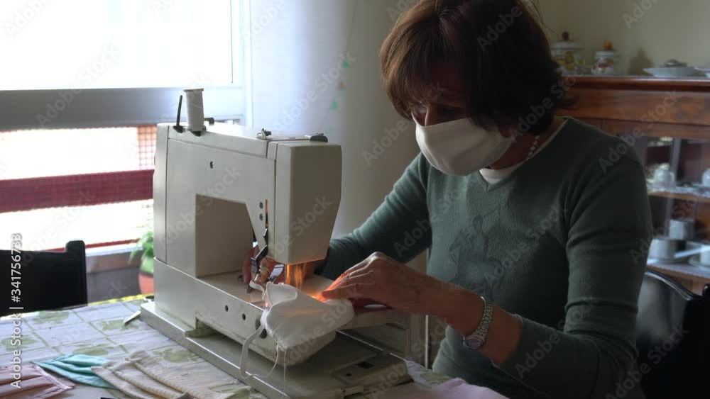 Italy , Milan - Old lady 70 years old sews homemade masks with a sewing ... Italy , Milan - Old lady 70 years old sews homemade masks with a sewing ...