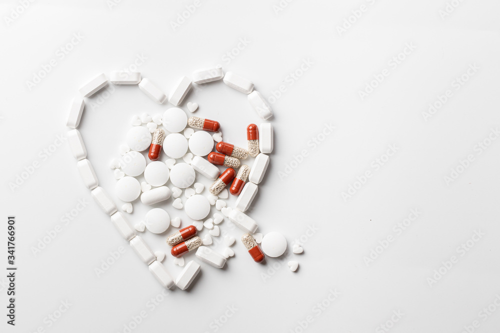 Many tablets are laid out in the form of a heart. Isolated white ...