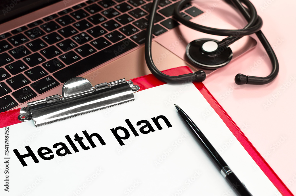 Text HEALTH PLAN on clipboard, stethoscope with medical form lying on ...