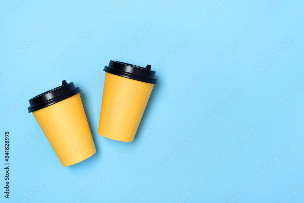Yellow paper cups on a light blue background. Flatlay. Coffee to go ...