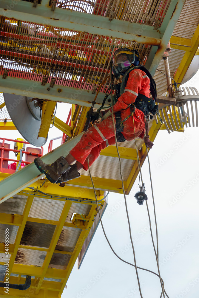 Working at heightWorking at height. A group of abseilers wearing red ...