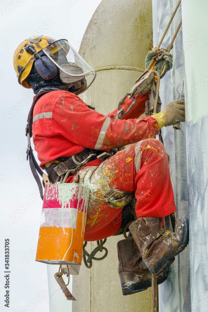 Working at height. Closed up abseiler wearing Personal Protective ...