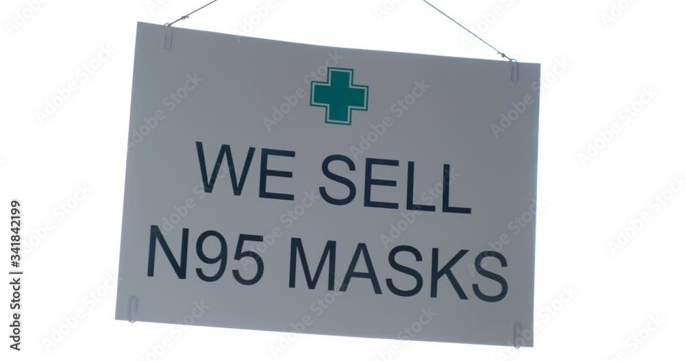 'We sell N95 masks' sign against a transparent window, swinging from ...