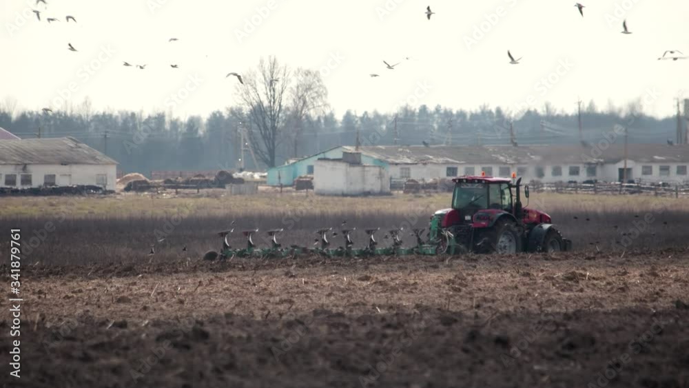 Vidéo Stock Side view of a farmer on a modern tractor with a multi-plow ...