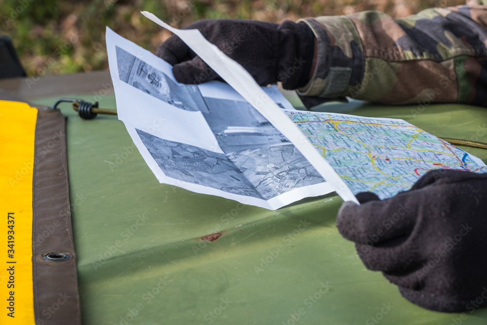 a soldier looking at a map during a simulation of conflict between ...