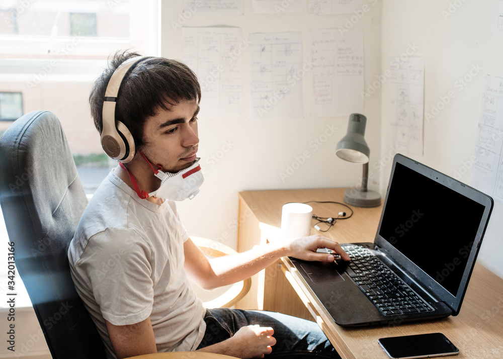 One sad Boy sitting on his chair wearing white shirt, jeans, white mask ...
