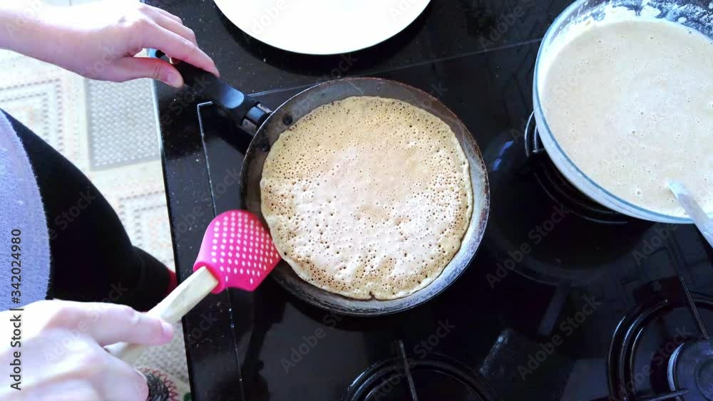 process of making pancakes in pan with granite coating. Hands of white ...