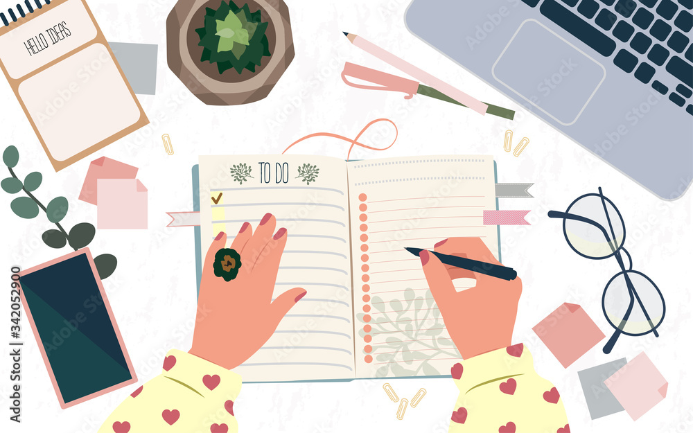 Woman's hands holding pen and writing down goals in notepad or making ...