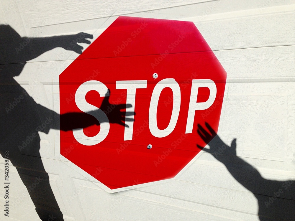 Optical Illusion Of Shadows Holding Stop Sign Painted On White Wall ...