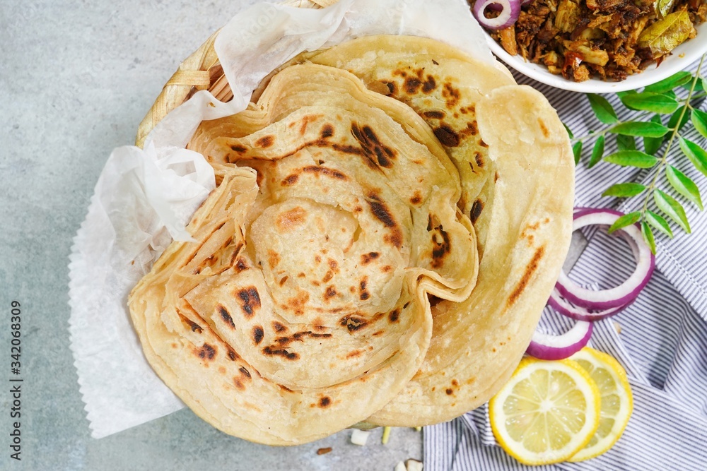 Lachha Paratha or Indian layered Roti with Pork Fry, selective focus ...