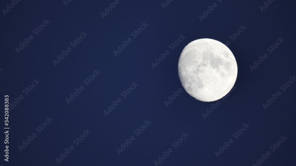 The full moon in sky moves across the horizon. Close-up moon, craters ...