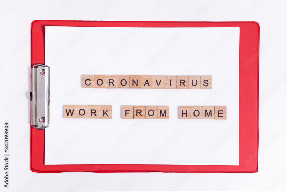 Text from wooden letters coronavirus work from home. Office red tablet ...
