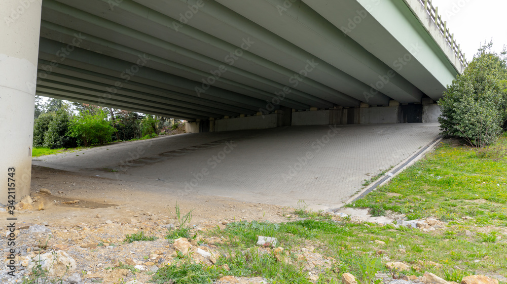 Common shelter that homeless people use as home under the bridge - side ...