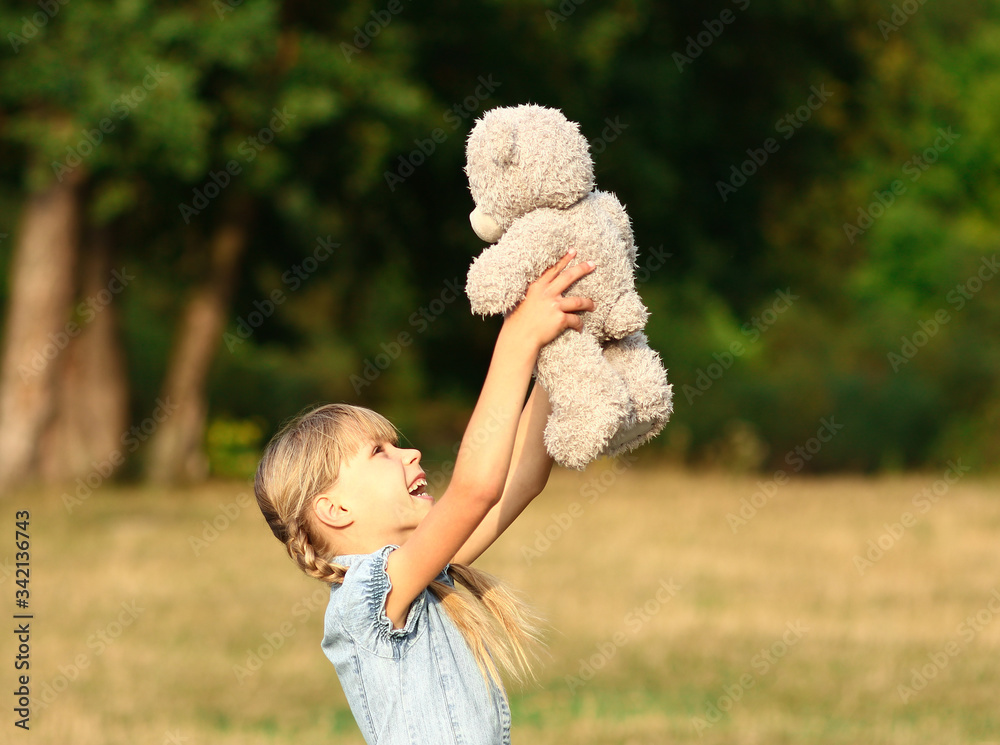 Little girl with a little bear on nature Stock Photo | Adobe Stock
