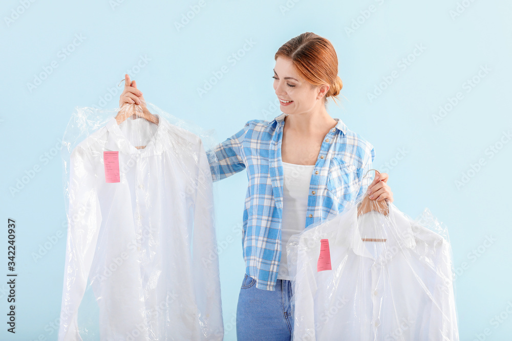 Worker of modern dry-cleaner's on color background Stock Photo | Adobe ...