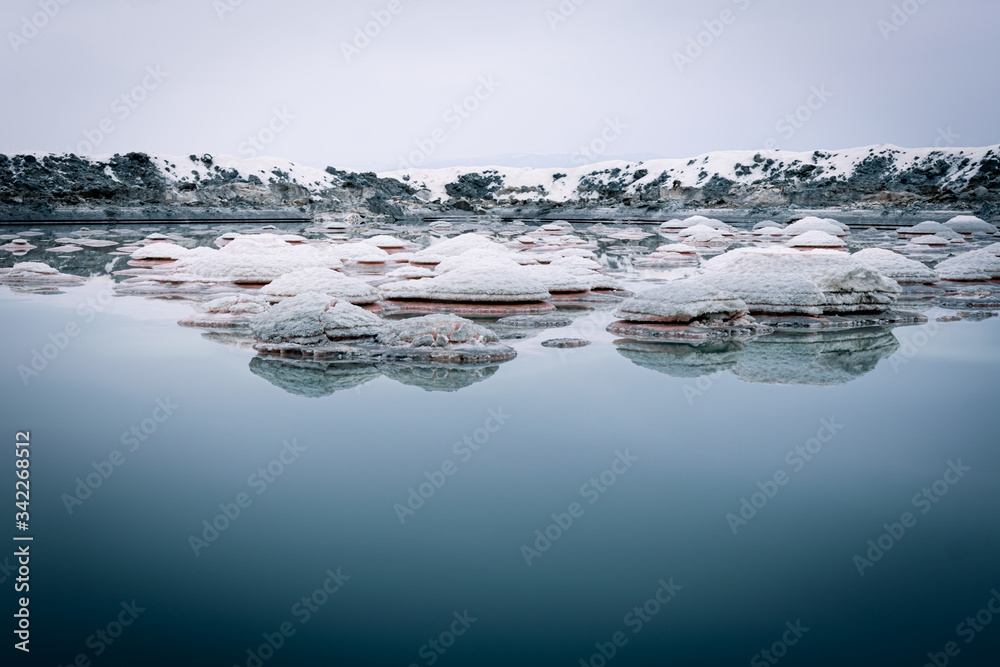 Salt reservoir pond with naturally forming salt crystals in the middle ...