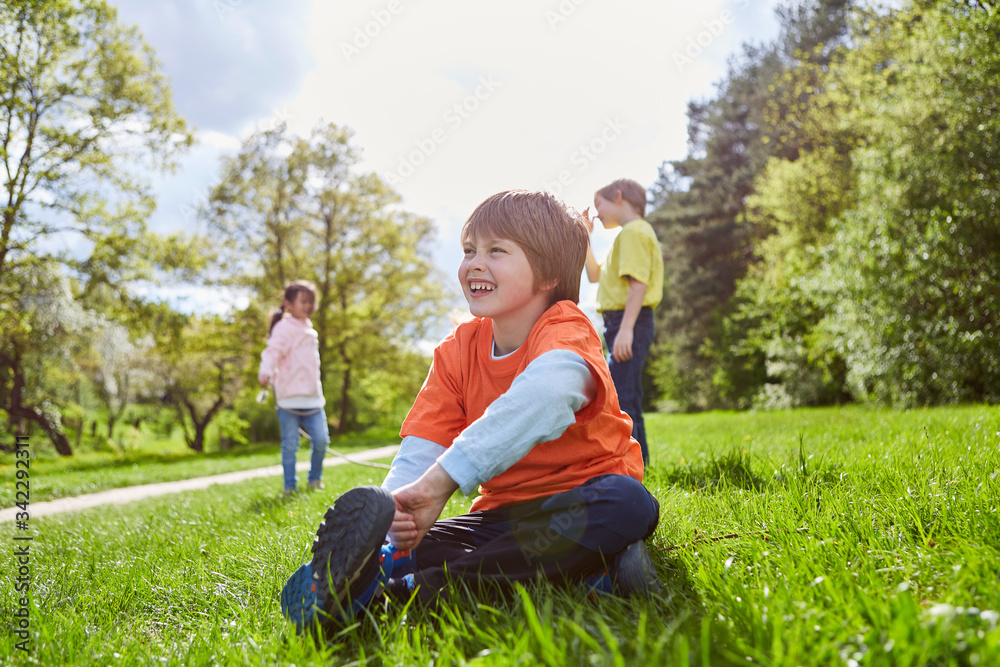 Boy is sitting on a meadow while playing Stock Photo | Adobe Stock