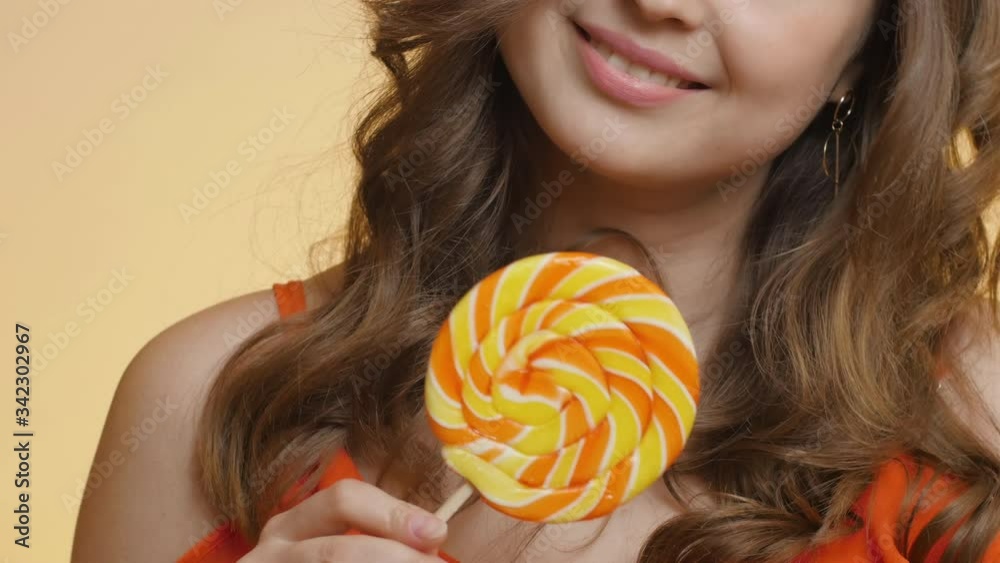 face close up cute girl with caramel candy on colored studio background ...