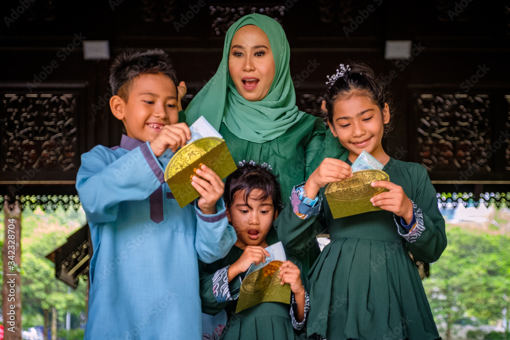Happy children holding an envelope of pocket money or raya angpao from ...