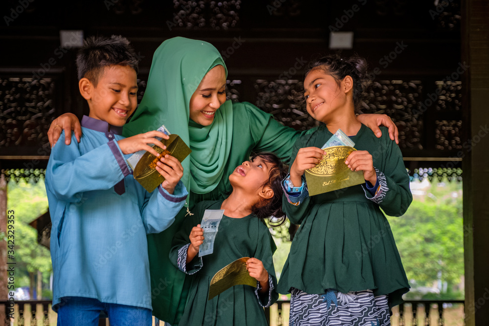 Happy children holding an envelope of pocket money or raya angpao from ...
