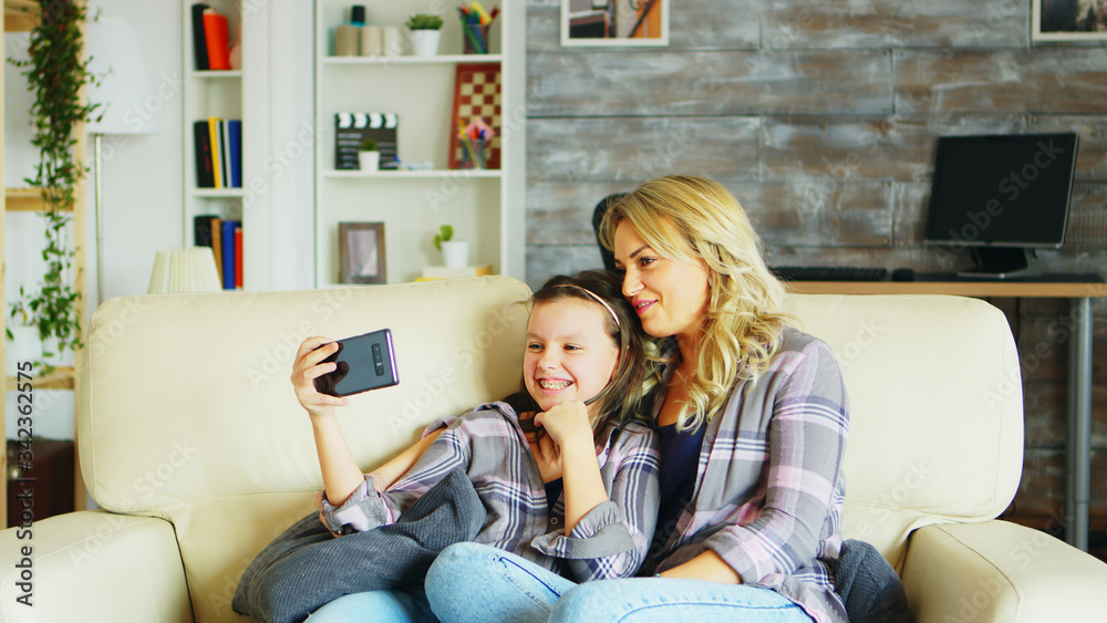 Little Girl And Her Mother Sitting On The Couch In Living Room Stock