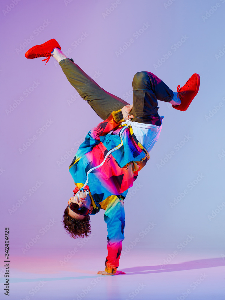 Guy dancing contemporary dance in studio. Neon light grey background ...