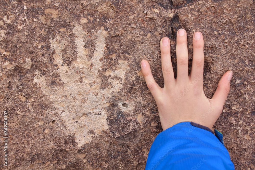 Hand Beside Handprint On Rock Stock Photo | Adobe Stock