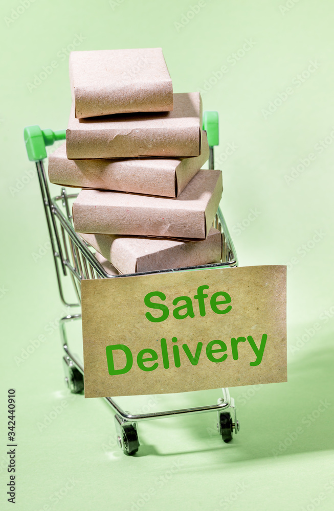 Stack of packed boxes in mini shopping trolley with label Safe Delivery ...