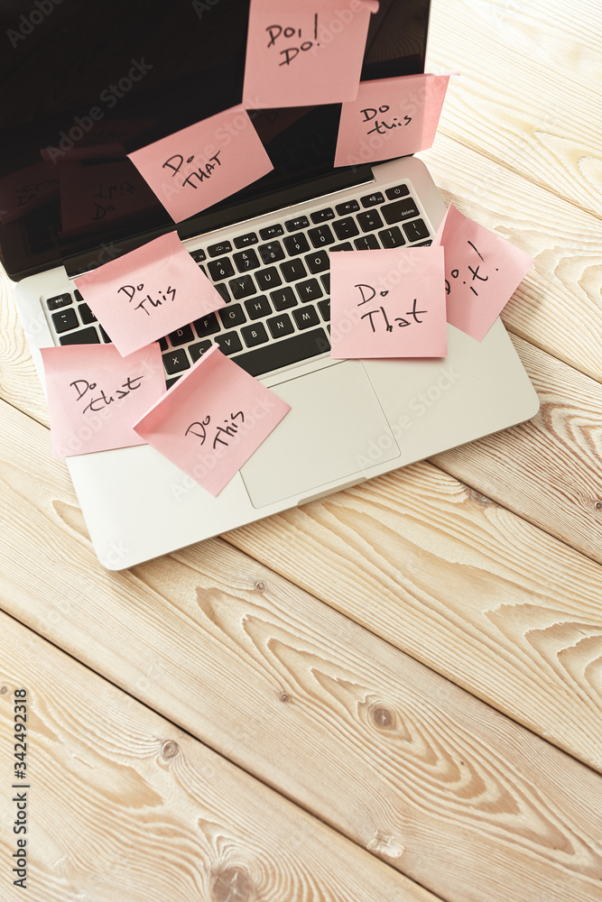Image of laptop full of sticky notes reminders on screen. Work overload ...