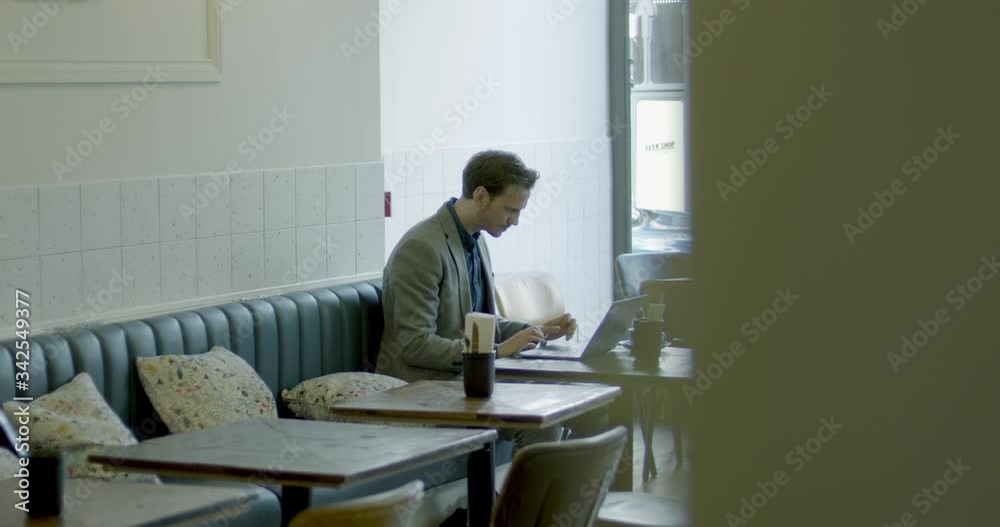 Businessman sitting and working in empty cafe restaurant on laptop. Man ...