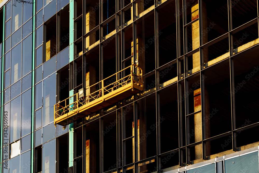 Suspended construction craddle near wall of hightower building with ...