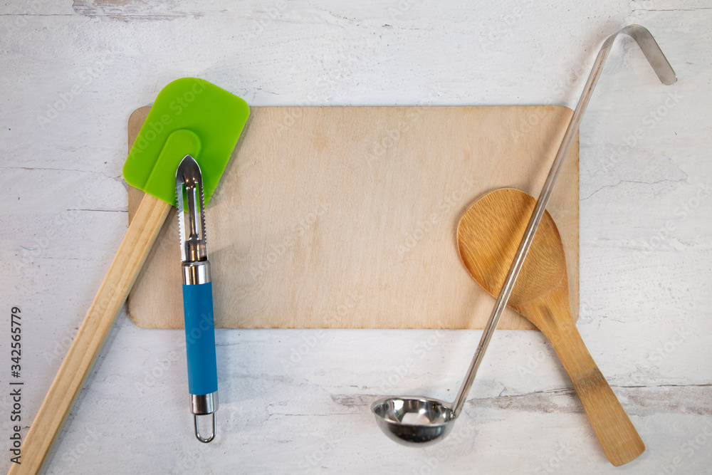 Cooking kitchen tools scattered framing a blank wooden sign no writing ...