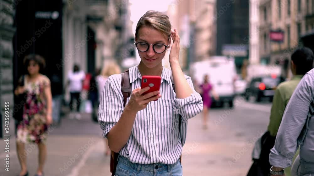 Slow motion effect of attractive caucasian female tourist standing on city street in metropolis ...