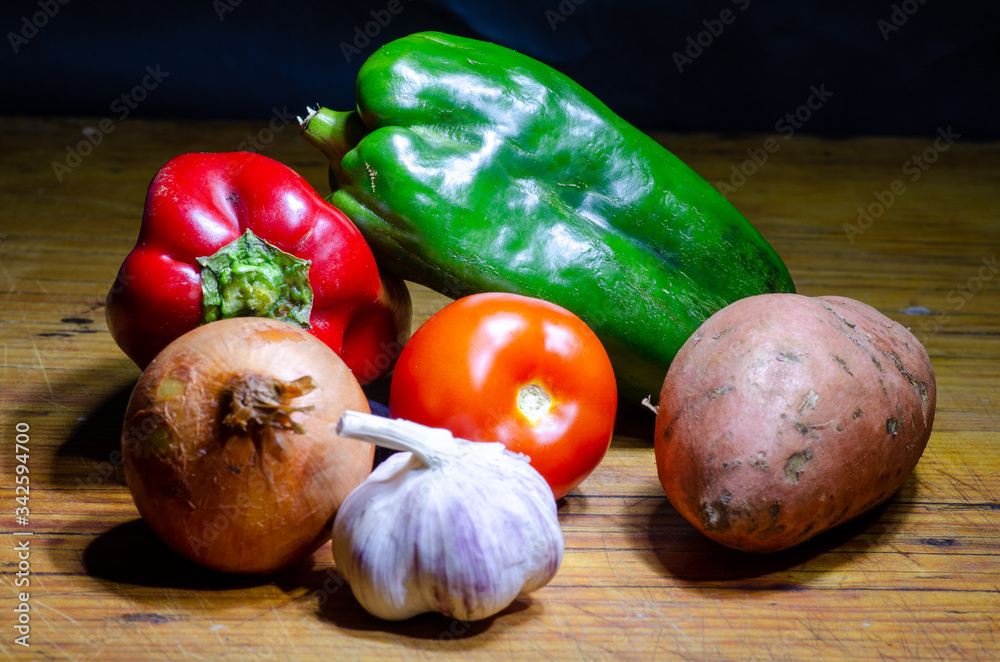 Pigmento ,verde ,rojo ,tomate cebolla y ajo sobre tabla rustica de ...