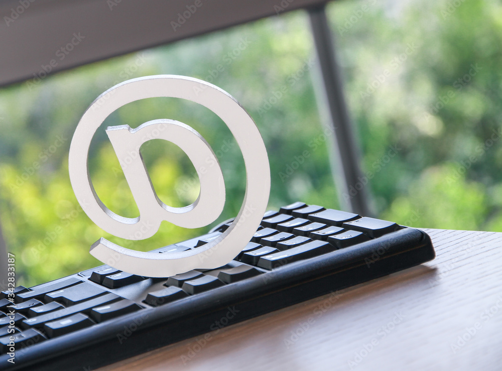 clean at-symbol, at-sign on keyboard with wood surface, symbol for mail ...