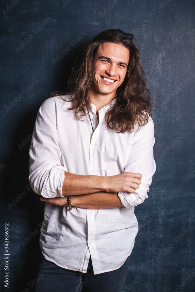 Handsome happy man in white shirt. Smiling guy with long hair on ...