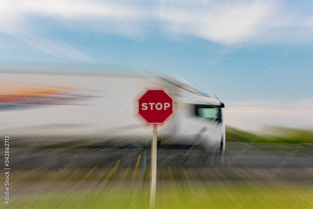 Stop traffic sign, and a truck circulating at high speed and in blurred ...