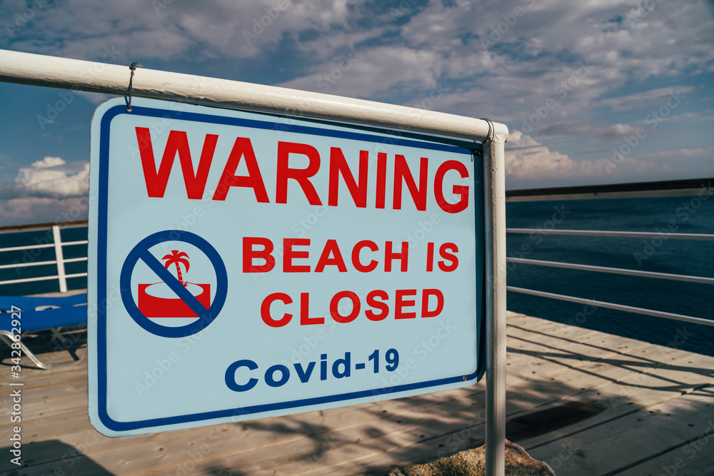 Beach is closed due to Covid-19 warning sign located at an entrance to ...