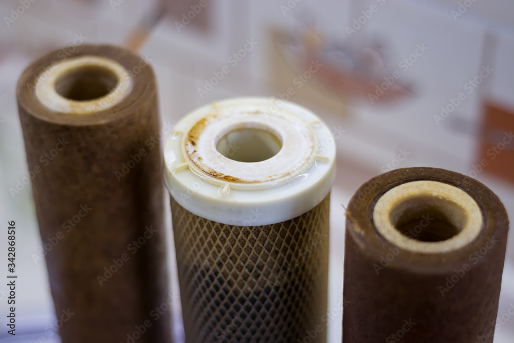 Dirty used reverse osmosis system cartridges on a kitchen background ...
