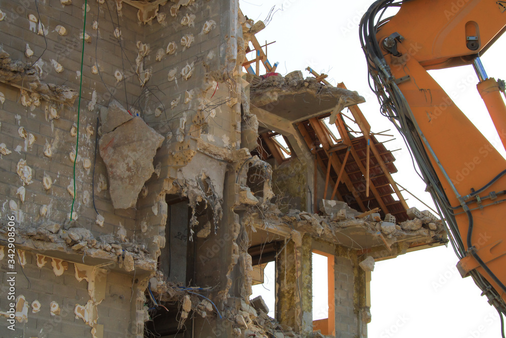 House being demolished. Construction equipment. Rubbs of a dilapidated ...