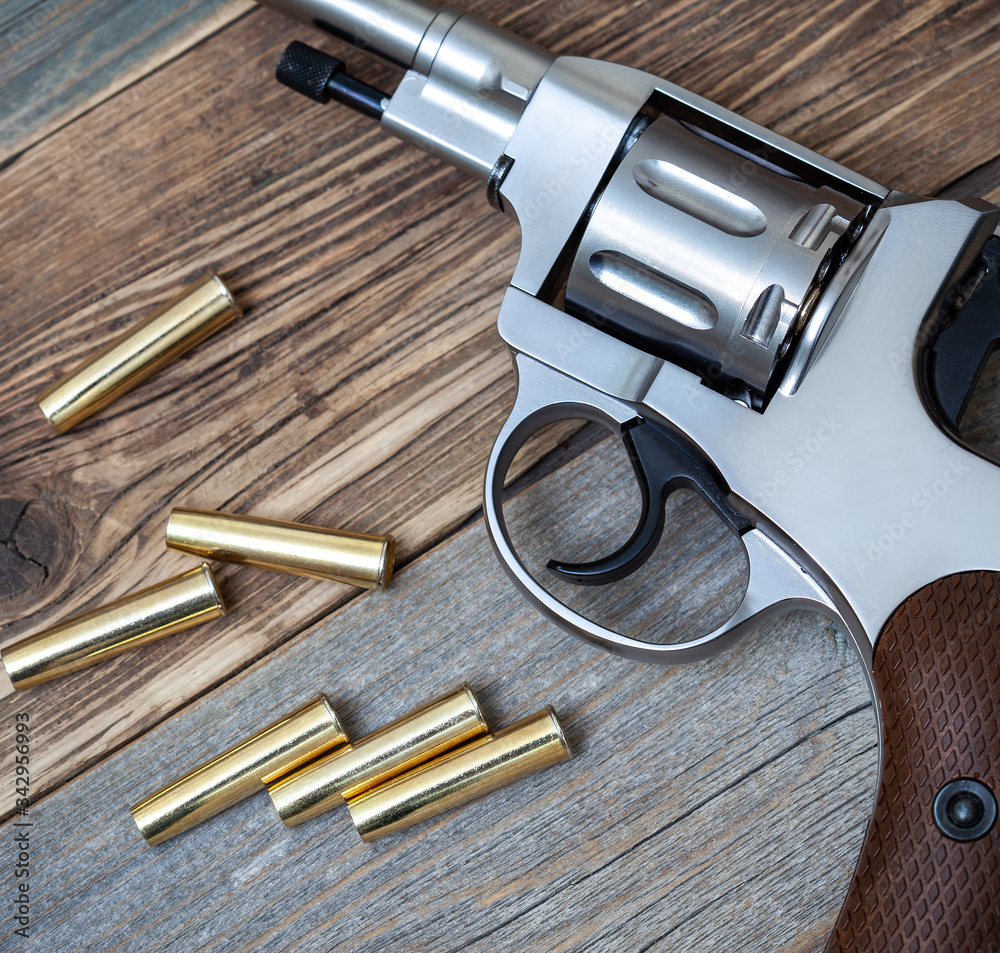 Silver revolver with cartridges Stock Photo | Adobe Stock