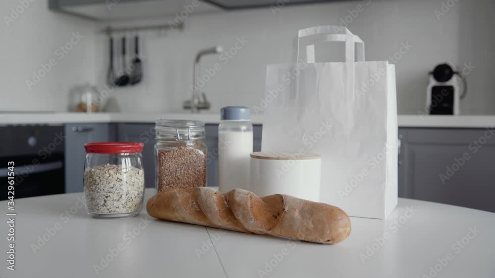 Unpacked shopping bag with bread, oatmeal, buckwheat, milk, vegetables ...